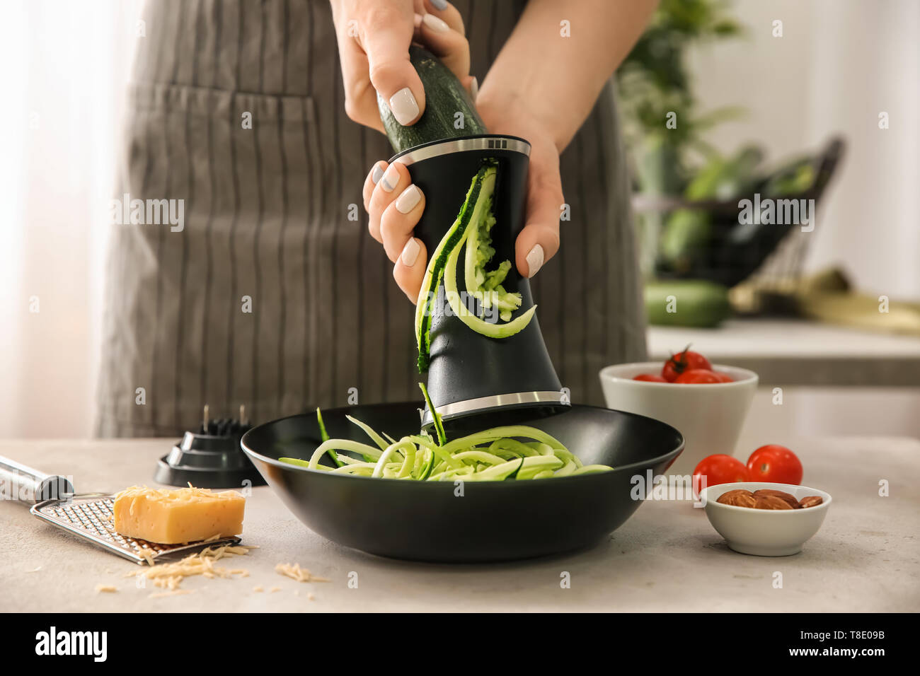 Woman grating zucchini in kitchen Stock Photo - Alamy