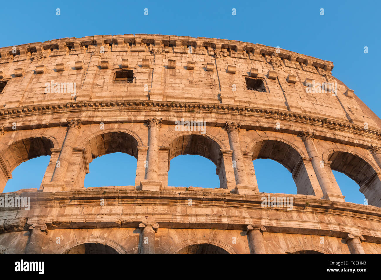 Front view of the arcs of Colosseum in sunset light. Rome Italy ...