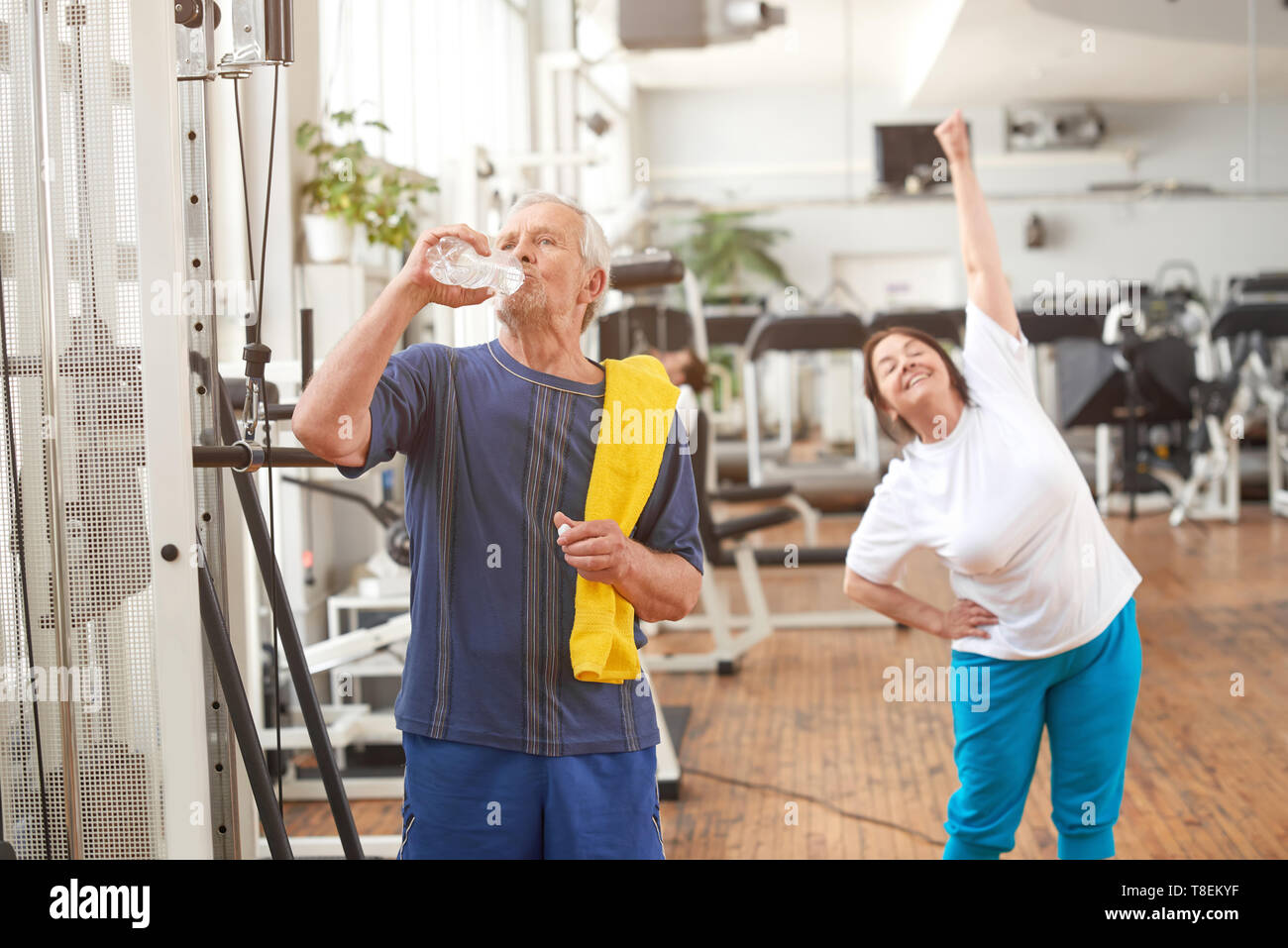 Senior man drinking water after workout. Elderly people at modern gym ... Senior man drinking water after workout. Elderly people at modern gym ...
