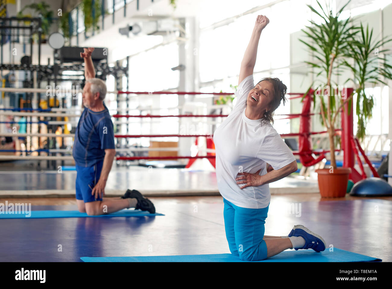 Beautiful mature woman doing exercise at gym. Elderly people working ...