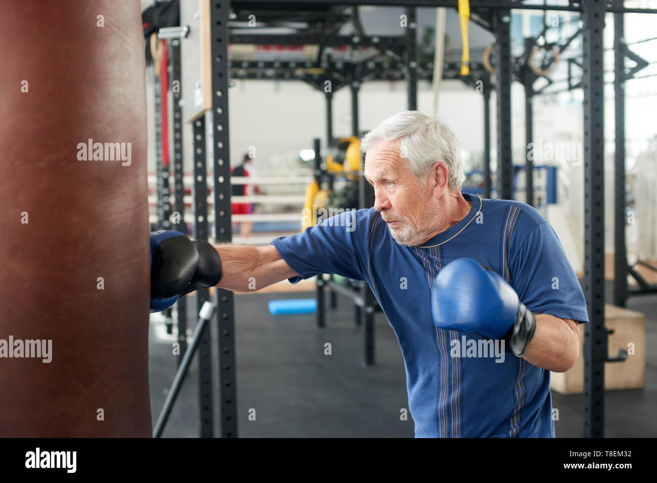 Elderly male person practicing box in gym. Healthy senior man in ...