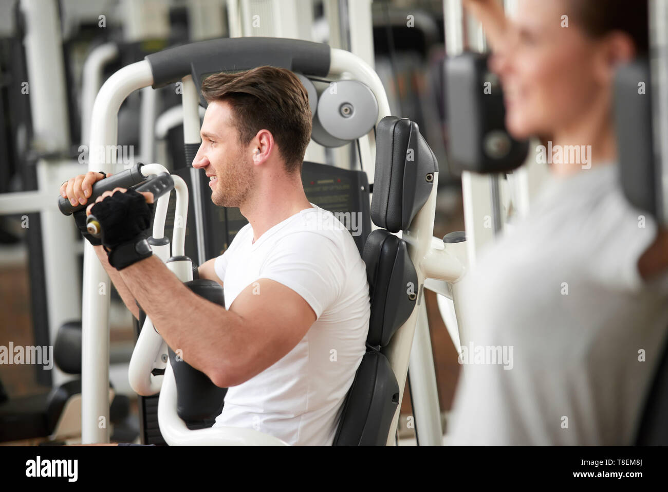 Young handsome man working out in fitness center. Handsome caucasian ...