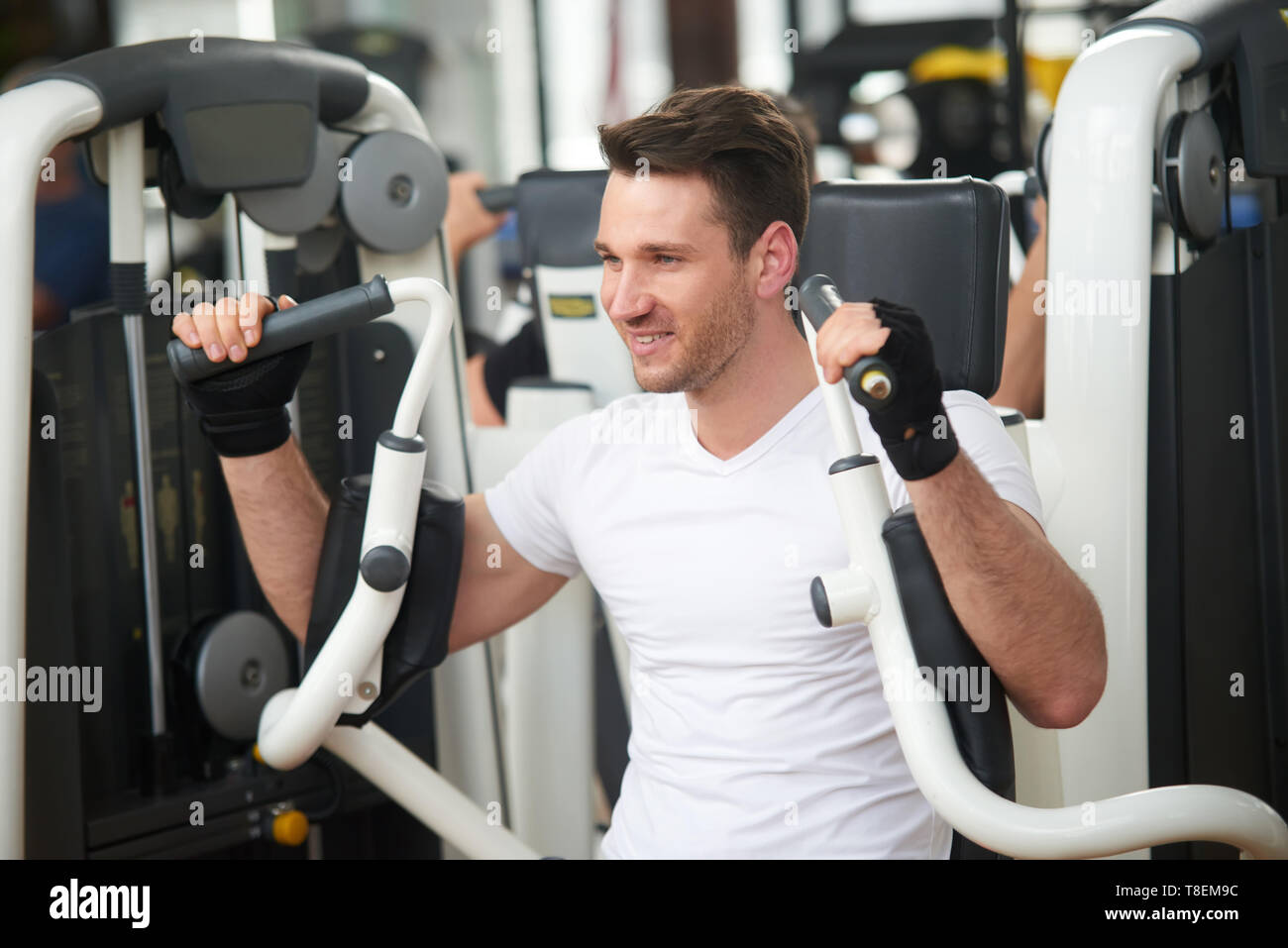 Man working out on chest press exercise. Smiling caucasian man working ...