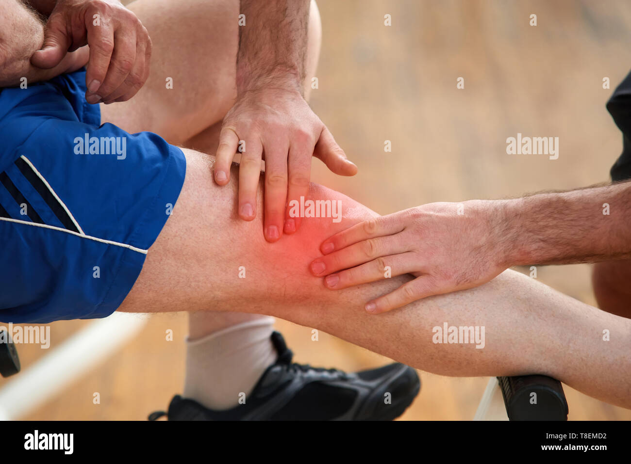 Sport injury at fitness club. Fitness trainer helps to man with injured ...