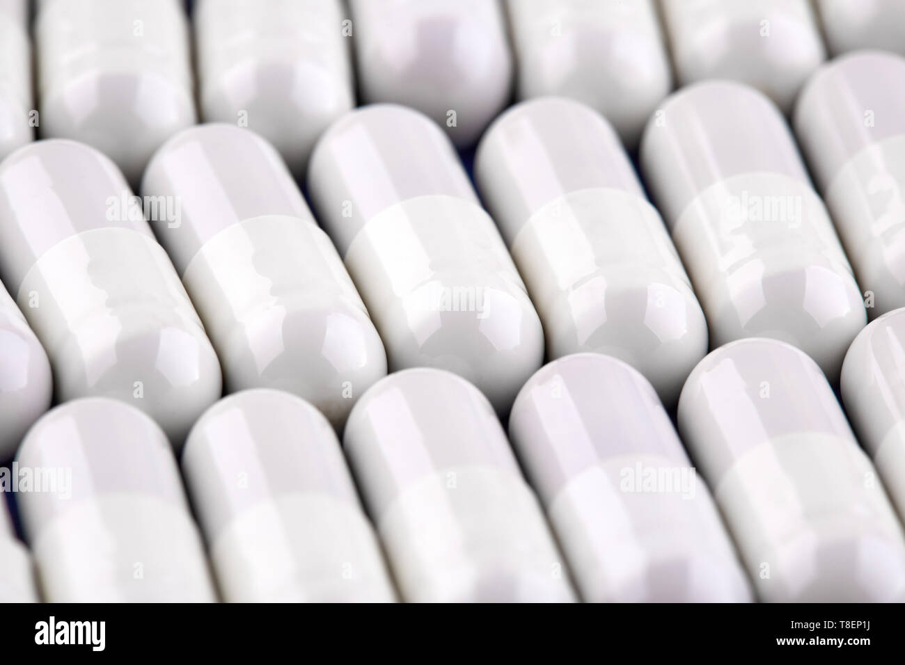 Close up photo of many white capsules with medicine Stock Photo - Alamy