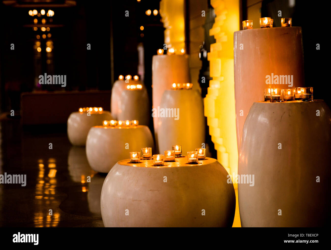 Flame of many candles burning on blurred lights background. Holiday ...