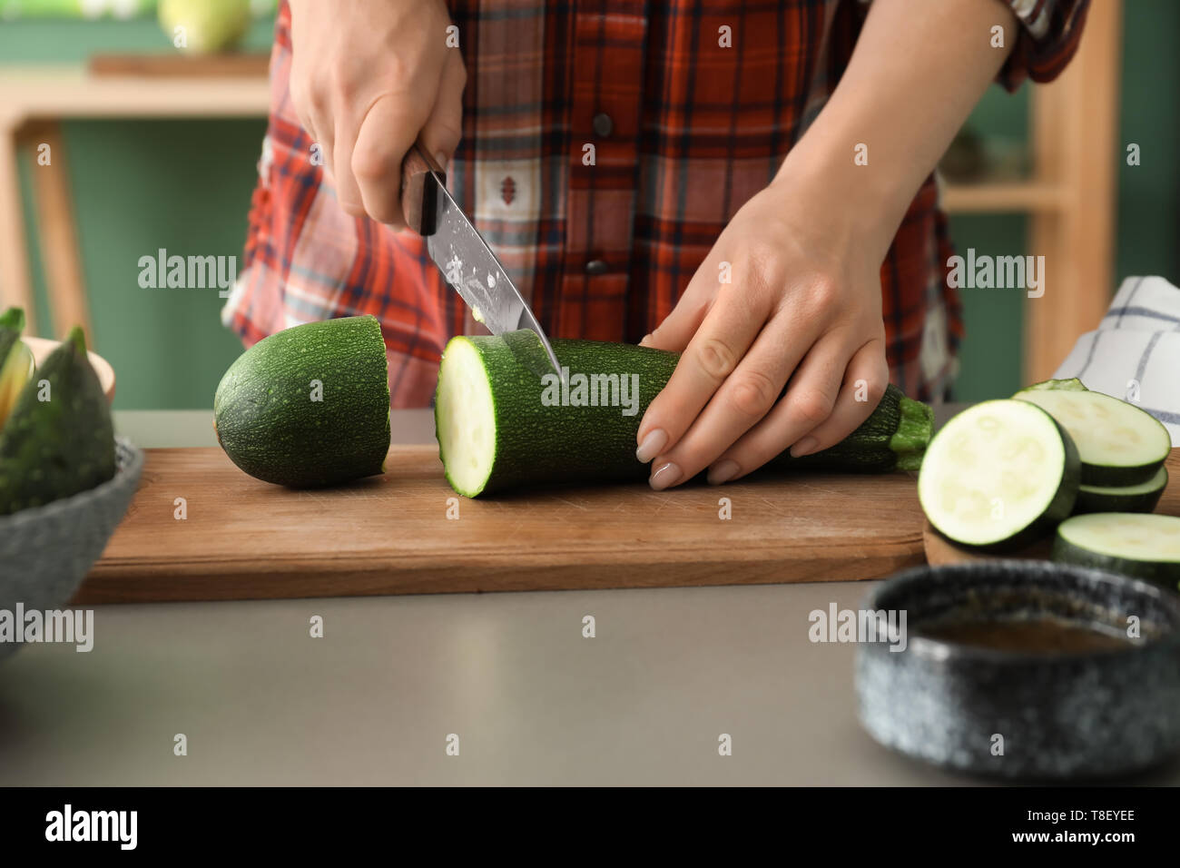 Woman cutting zucchini in kitchen Stock Photo - Alamy