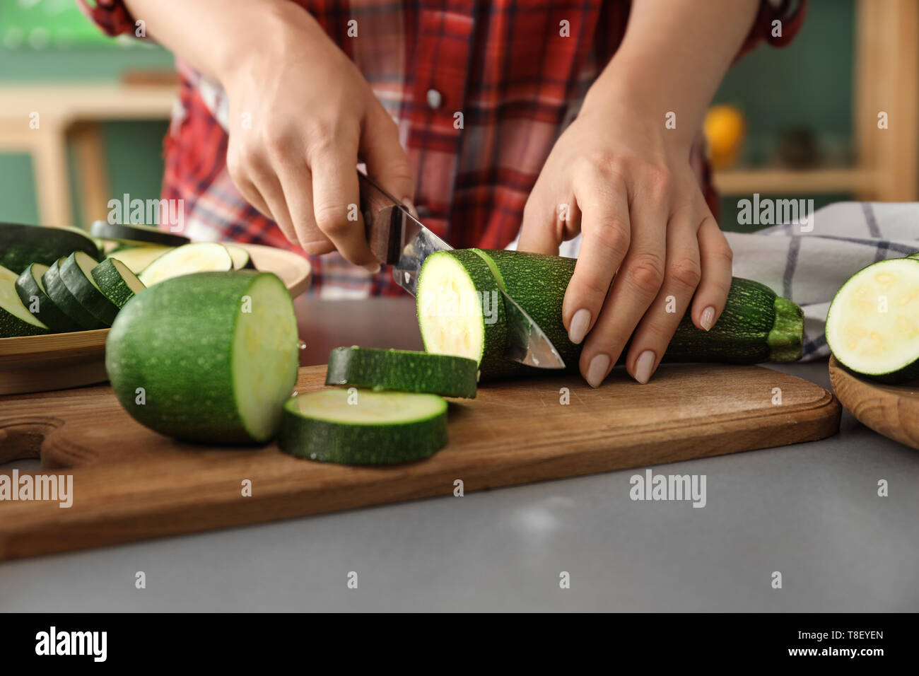 Woman cutting zucchini in kitchen Stock Photo - Alamy