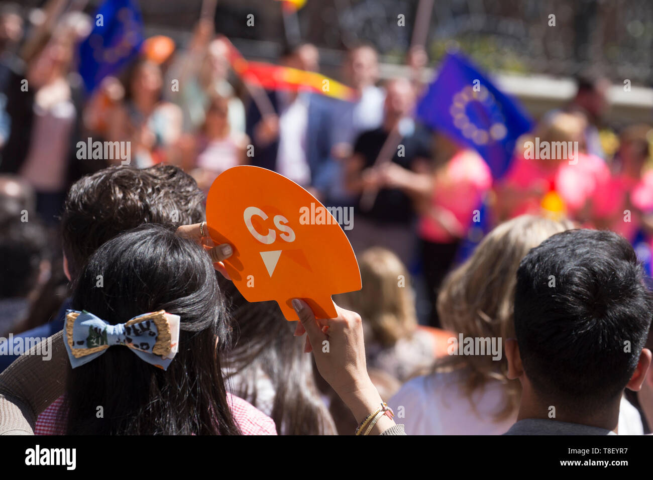 People seen protecting themselves from the sun with fans with the logo ...