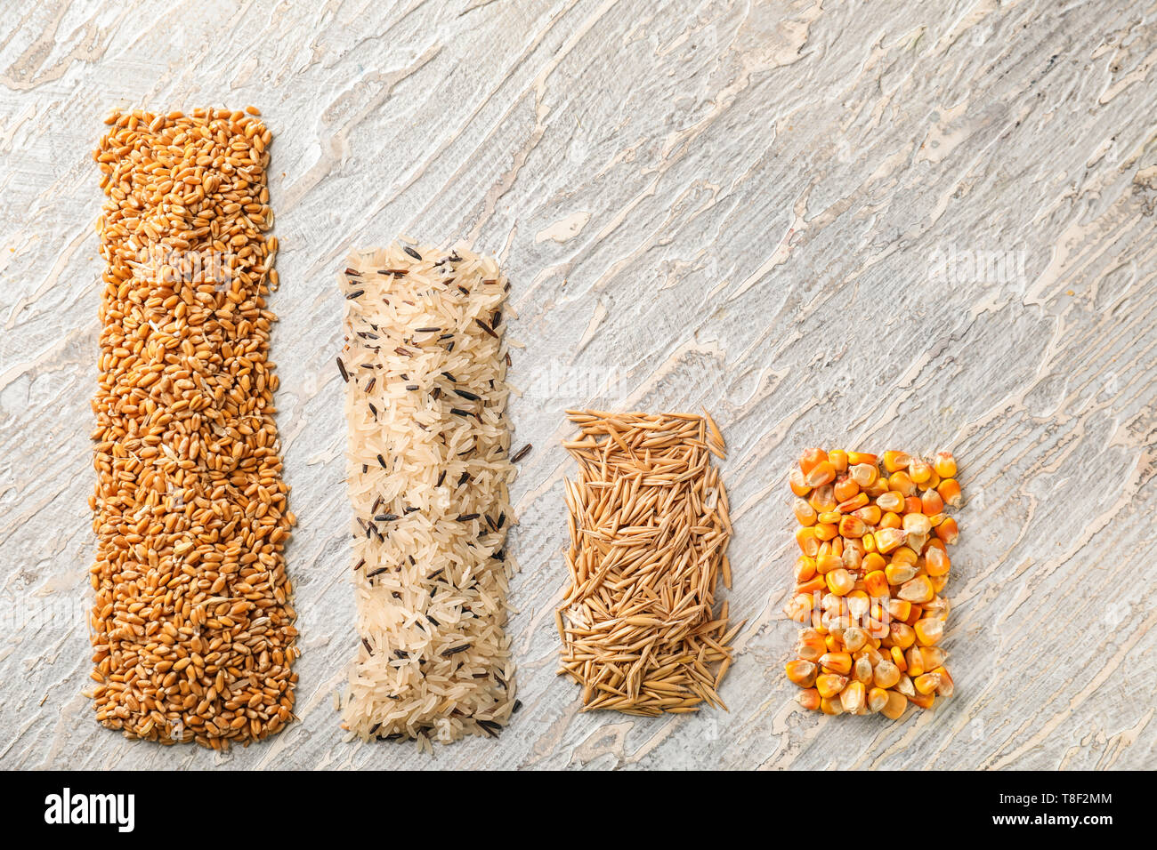 Different types of grains and cereals on light wooden table Stock Photo ...