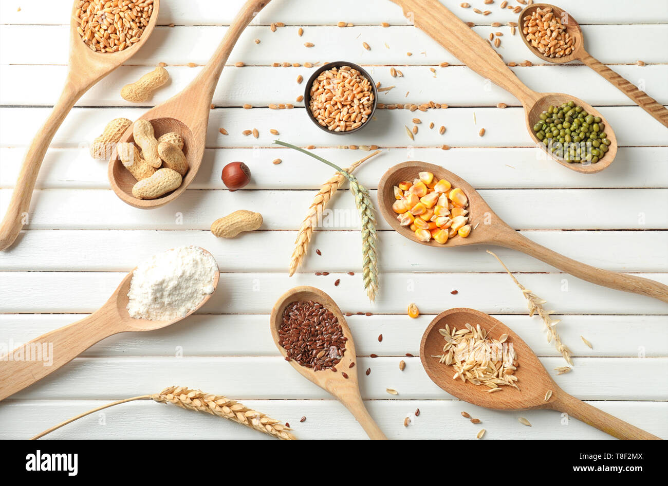 Different types of grains and cereals on white wooden table Stock Photo ...