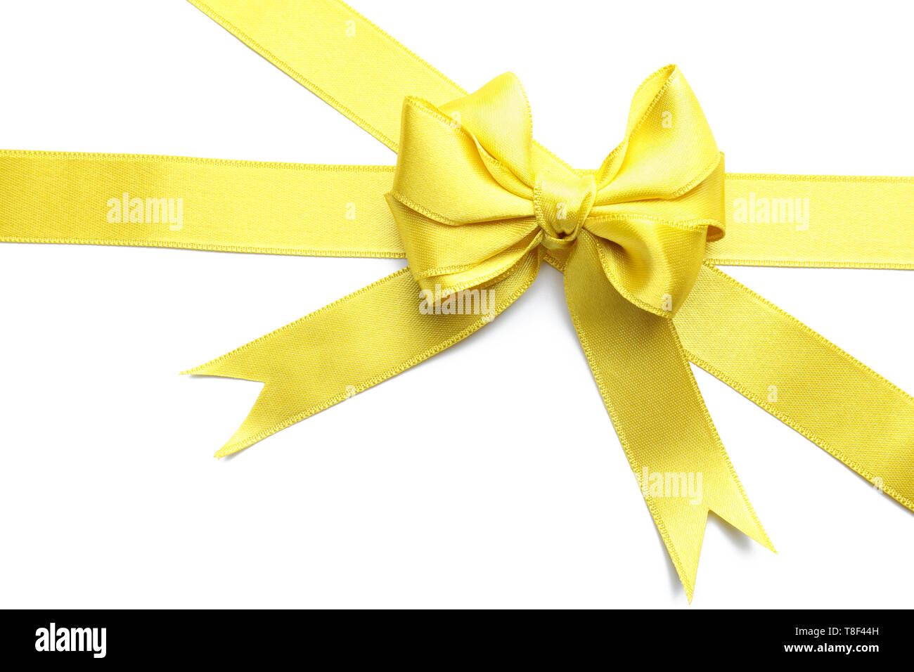 Yellow satin ribbons with bow on white background Stock Photo - Alamy