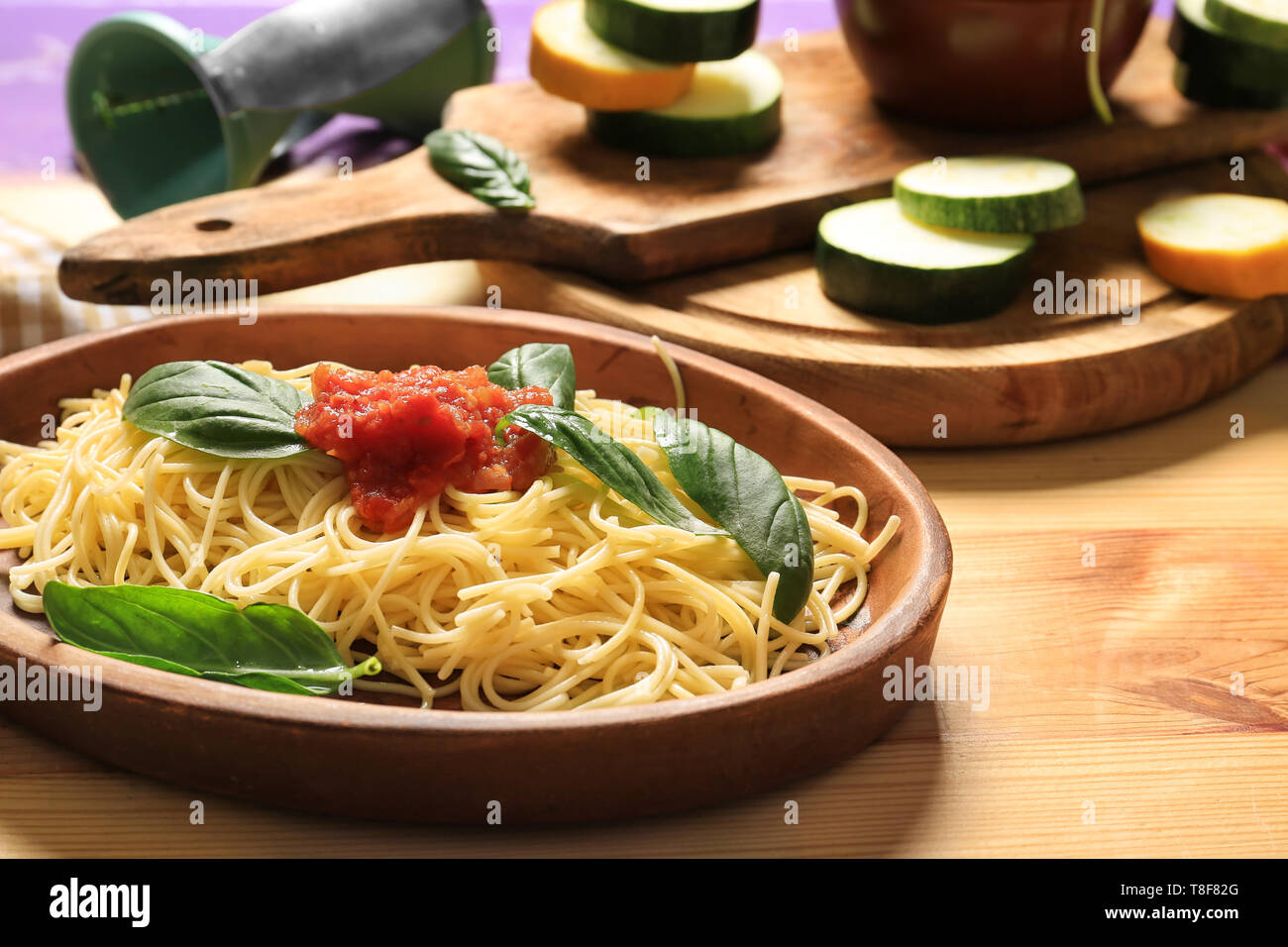 Plate with tasty spaghetti and tomato sauce on wooden table Stock Photo ...