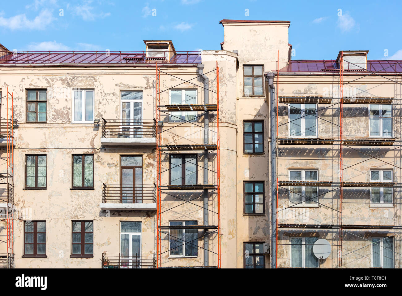 old residential building under reconstruction. metal scaffolding near ...
