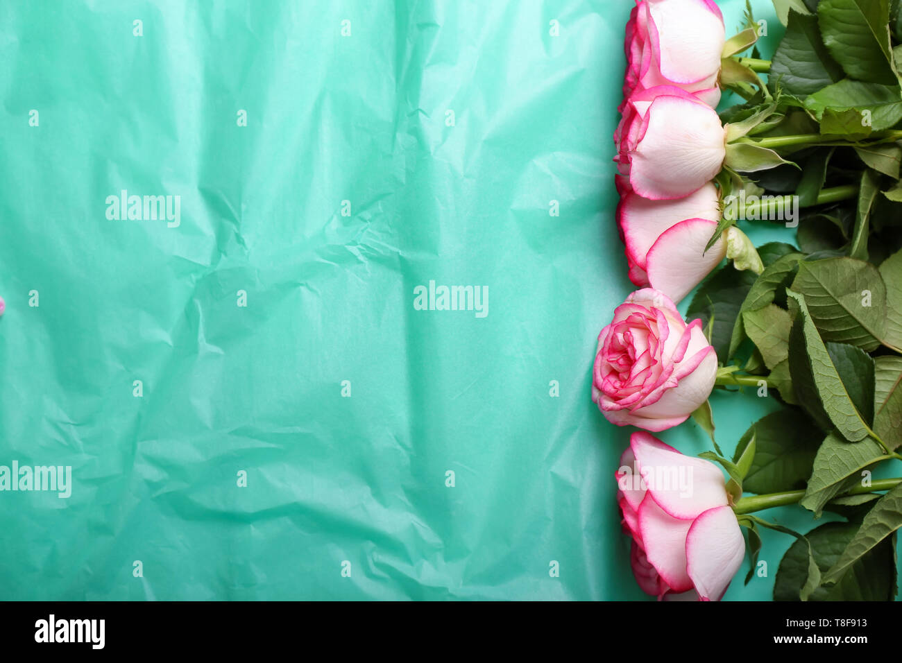 Beautiful roses on crumpled wrapping paper Stock Photo - Alamy