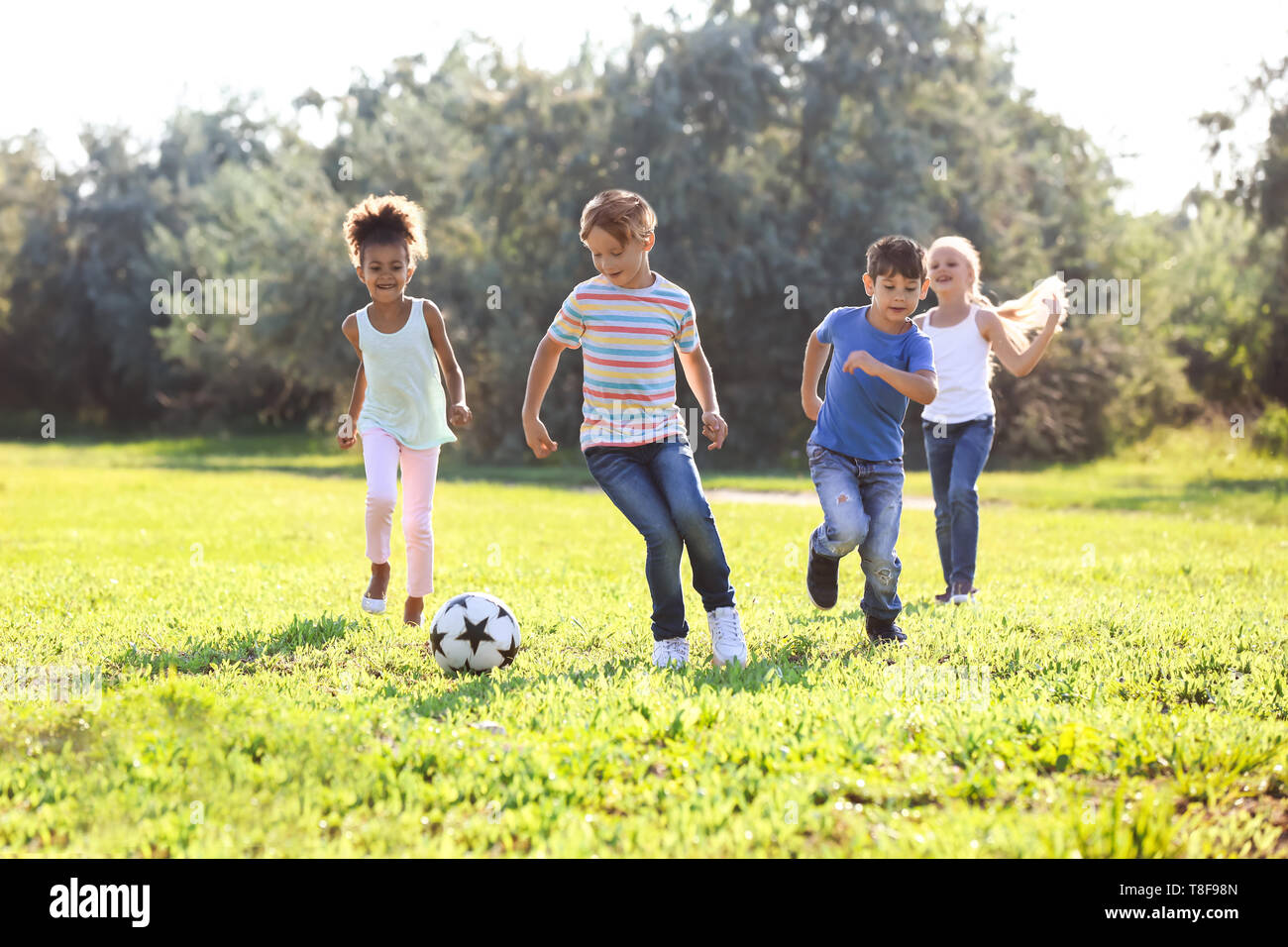 Cute little children playing football outdoors Stock Photo - Alamy