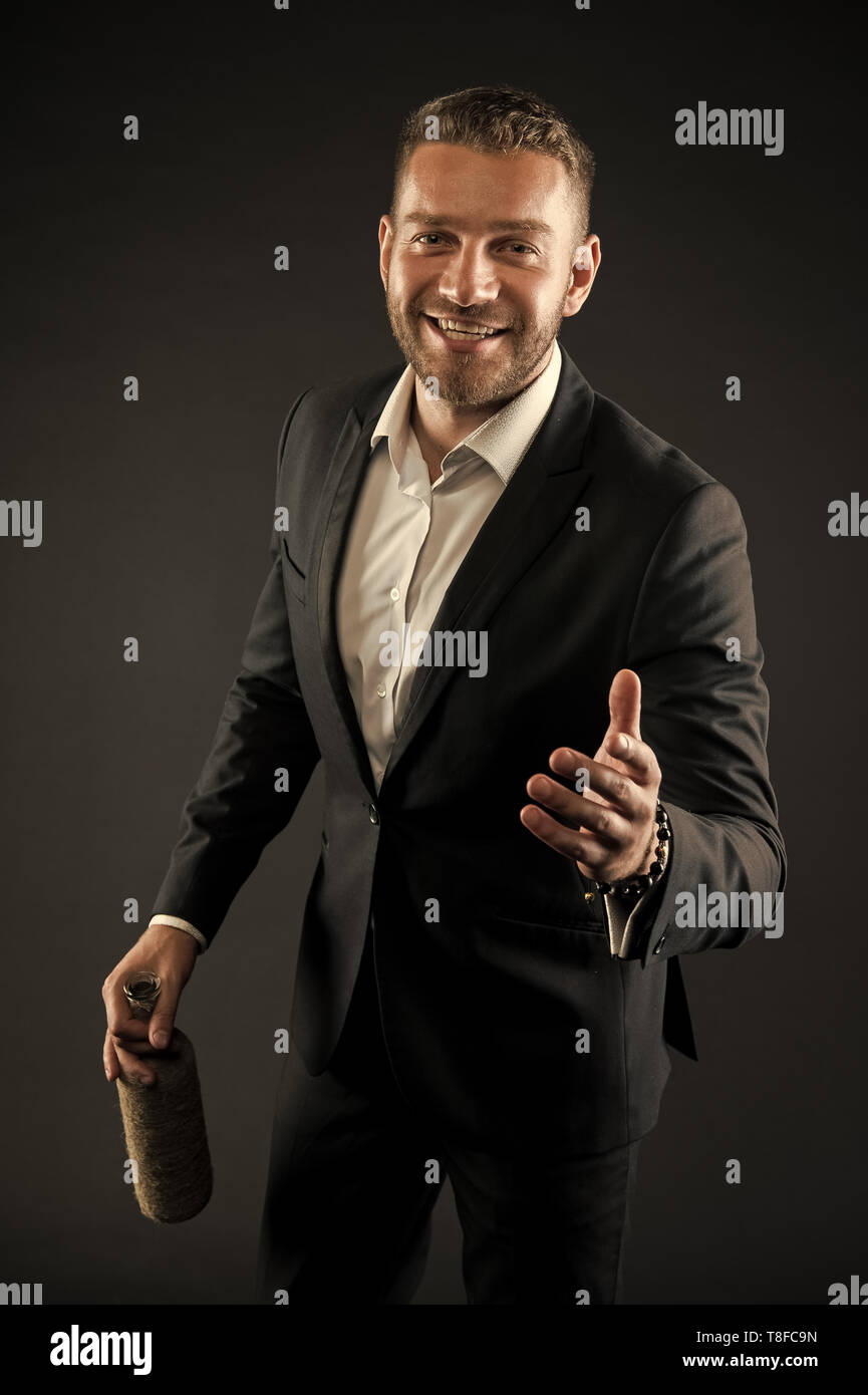 Businessman or man in formal suit cheerfully welcomes on dark ...