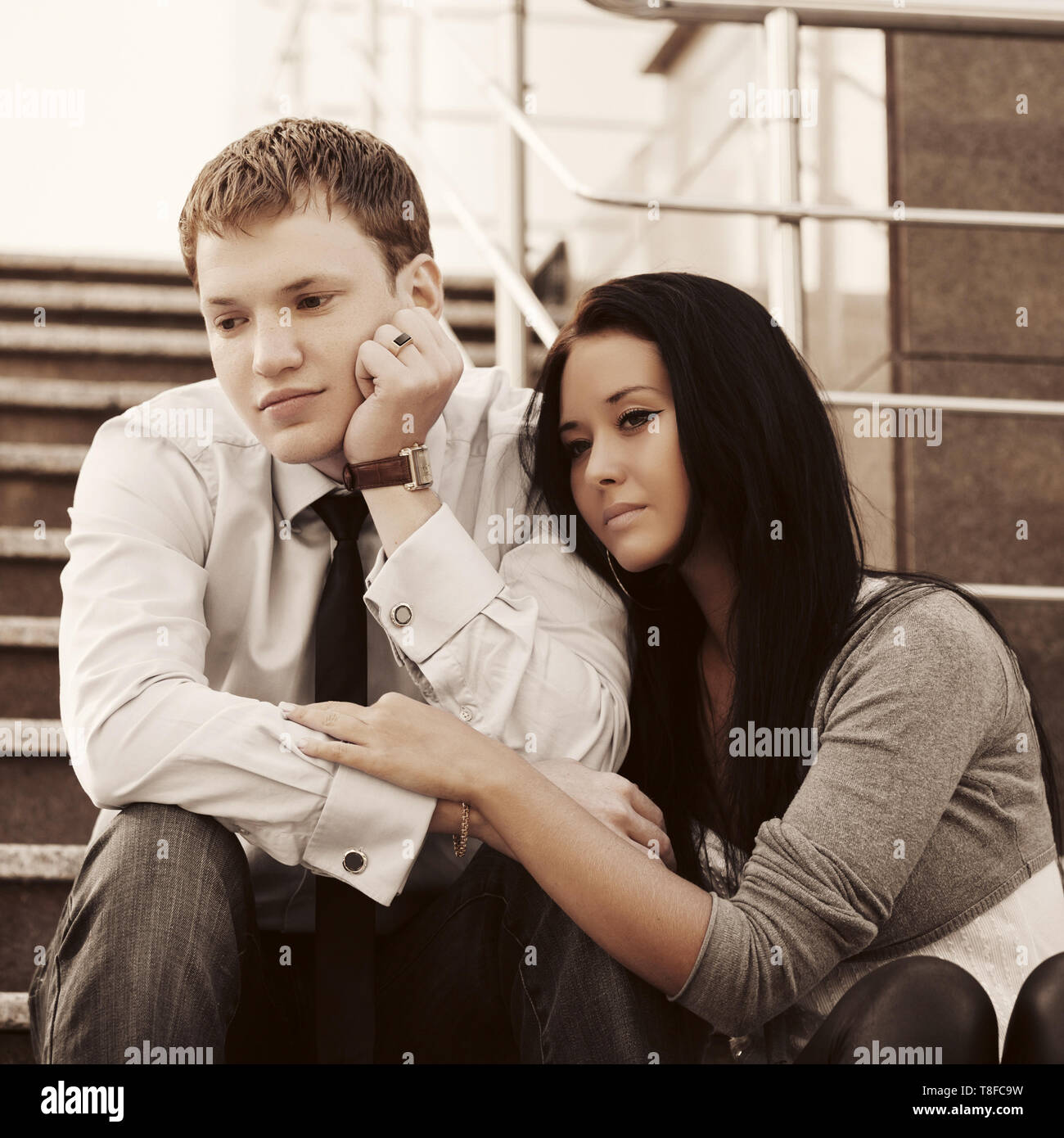 Sad young man and woman in depression sitting on the steps Stock Photo ...