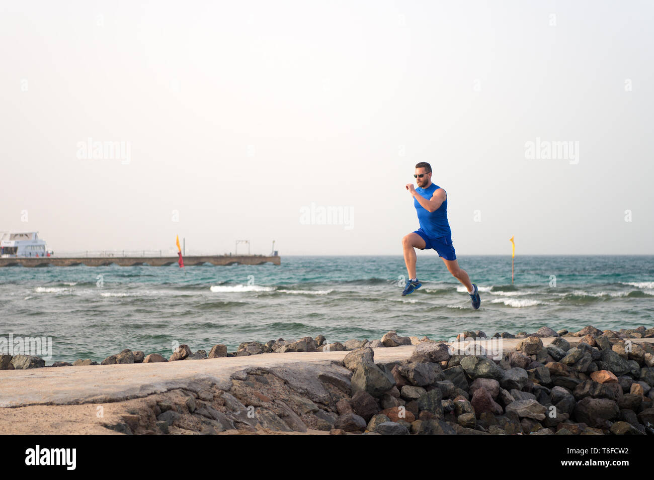 athlete runner along sea coast. running to success. summer vacation ...