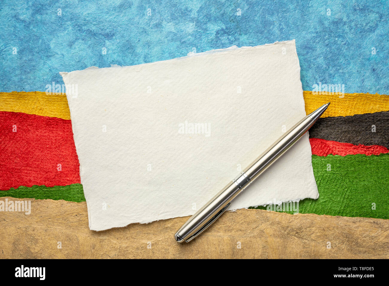 blank sheet of white rag paper with a pen against abstract landscape ...