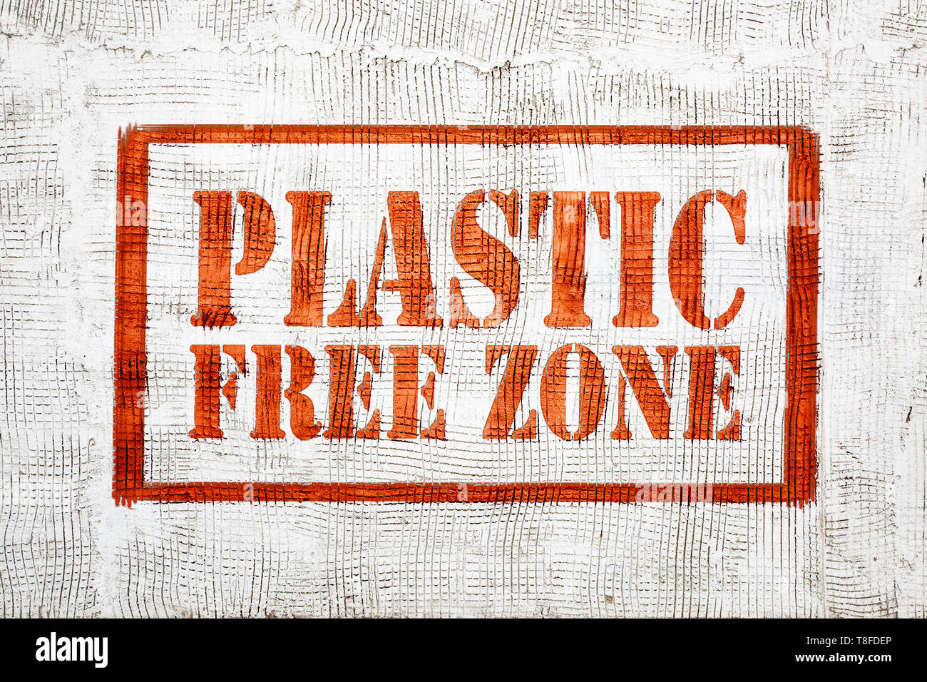 plastic free zone - red graffiti style sign on a white stucco wall ...
