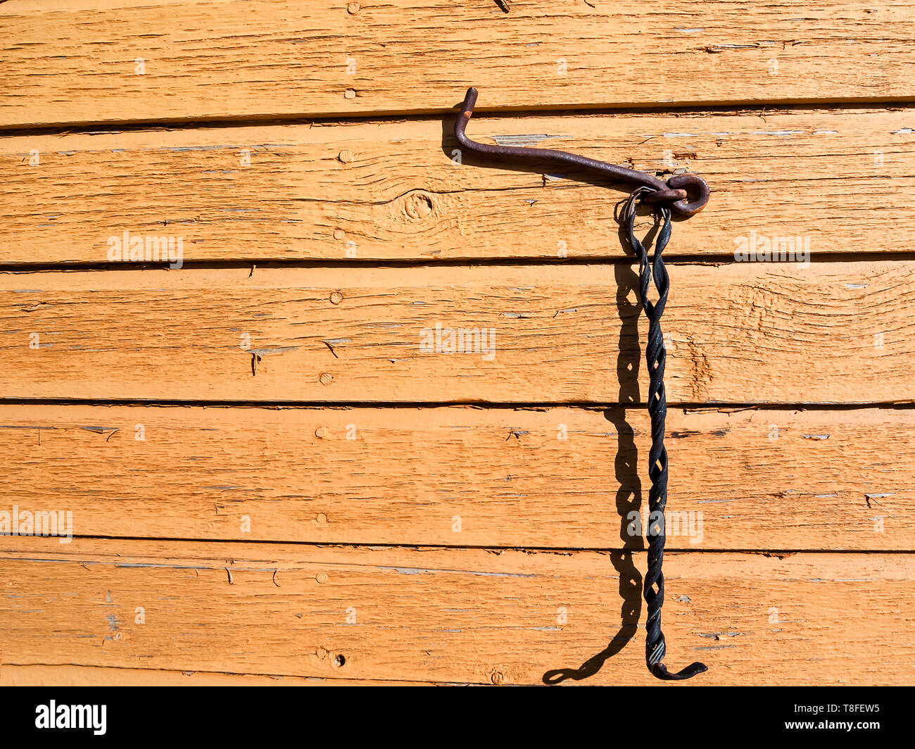 Two old hooks on a yellow wall at the museum area in Kalajoki, Finland ...