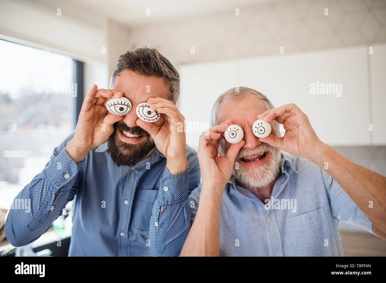 A Portrait Of Adult Hipster Son And Senior Father Indoors At Home