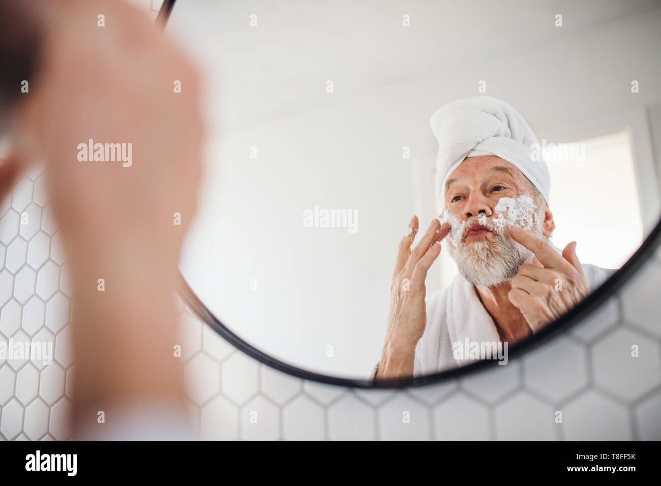 A senior man doing morning routine in bathroom indoors at home. Copy ...