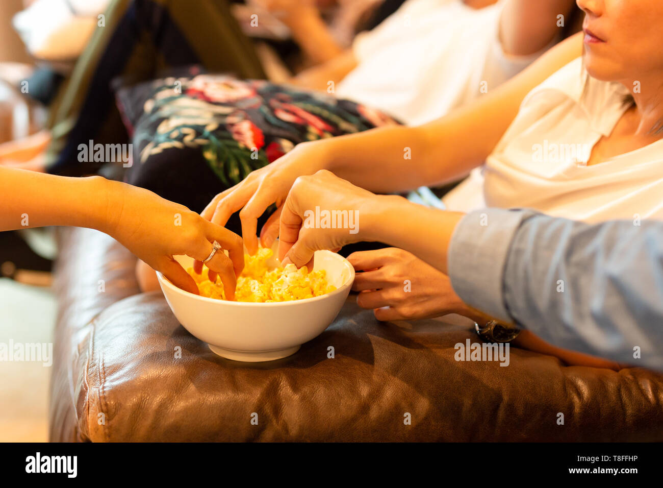 Woman hands taking popcorn from bowl watching movie with friend Stock ...