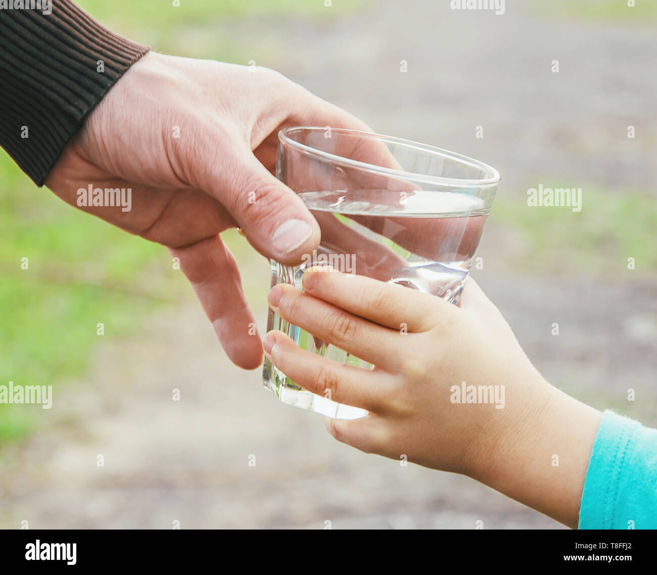 The father gives the child a glass of water. Selective focus. drink Stock Photo - Alamy