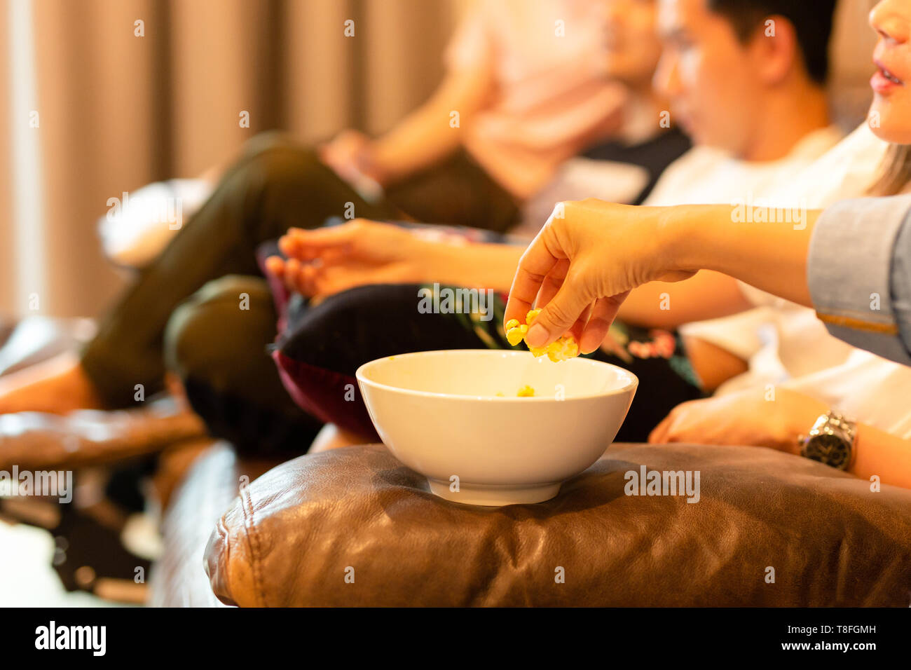 Woman hands taking popcorn from bowl watching movie with friend Stock ...