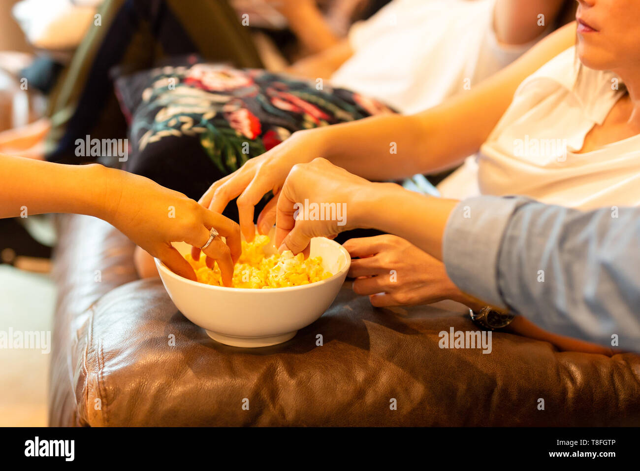 Woman hands taking popcorn from bowl watching movie with friend Stock ...