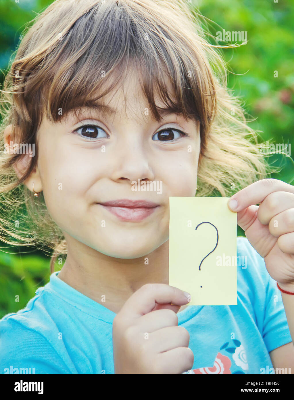 A child holding a sheet of paper with a question mark Stock Photo - Alamy