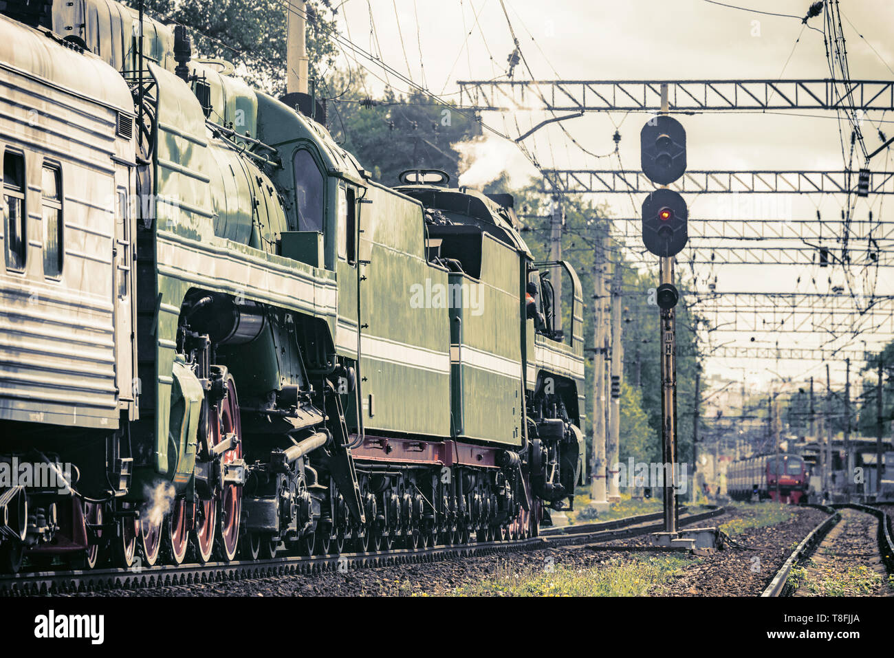 Retro steam train approaches to the station Stock Photo - Alamy