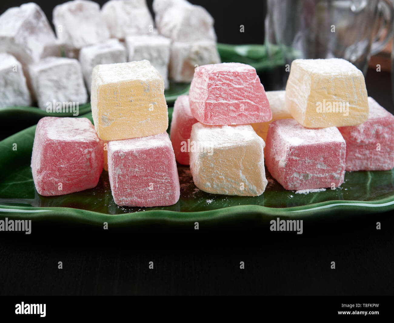 Turkish delight on a green leaf shaped tray, on dark brown background ...