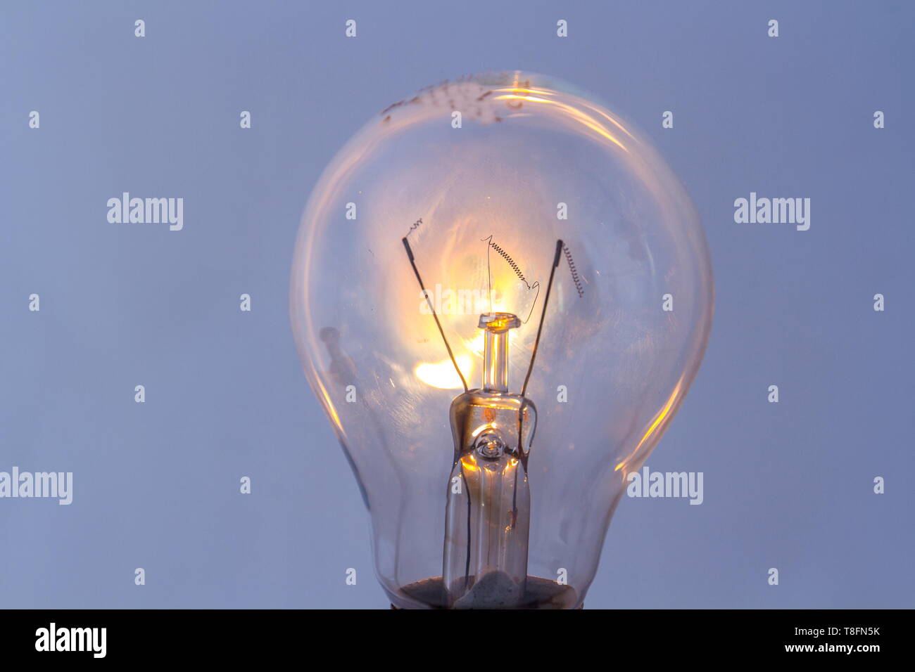 A dead electrical light bulb with a burning match behind it image in ...