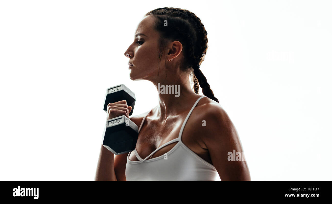 Female fitness model exercising with dumbbell. Young woman lifting ...