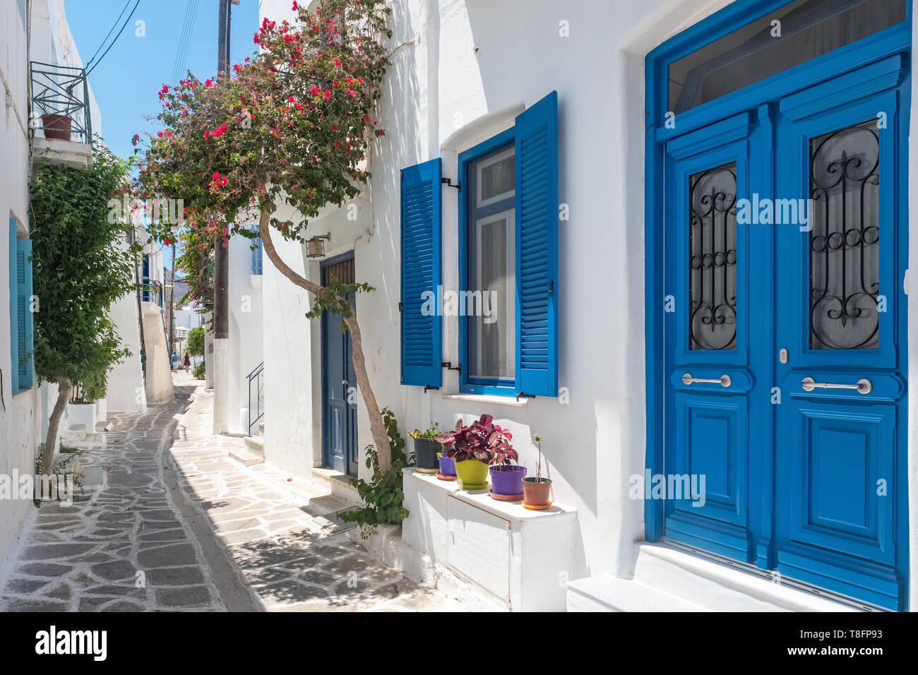 View of a typical narrow street in old town of Naoussa, Paros island ...