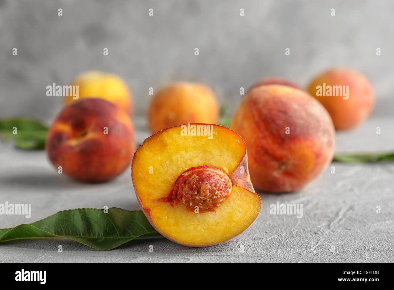 Cut peach on light table Stock Photo - Alamy