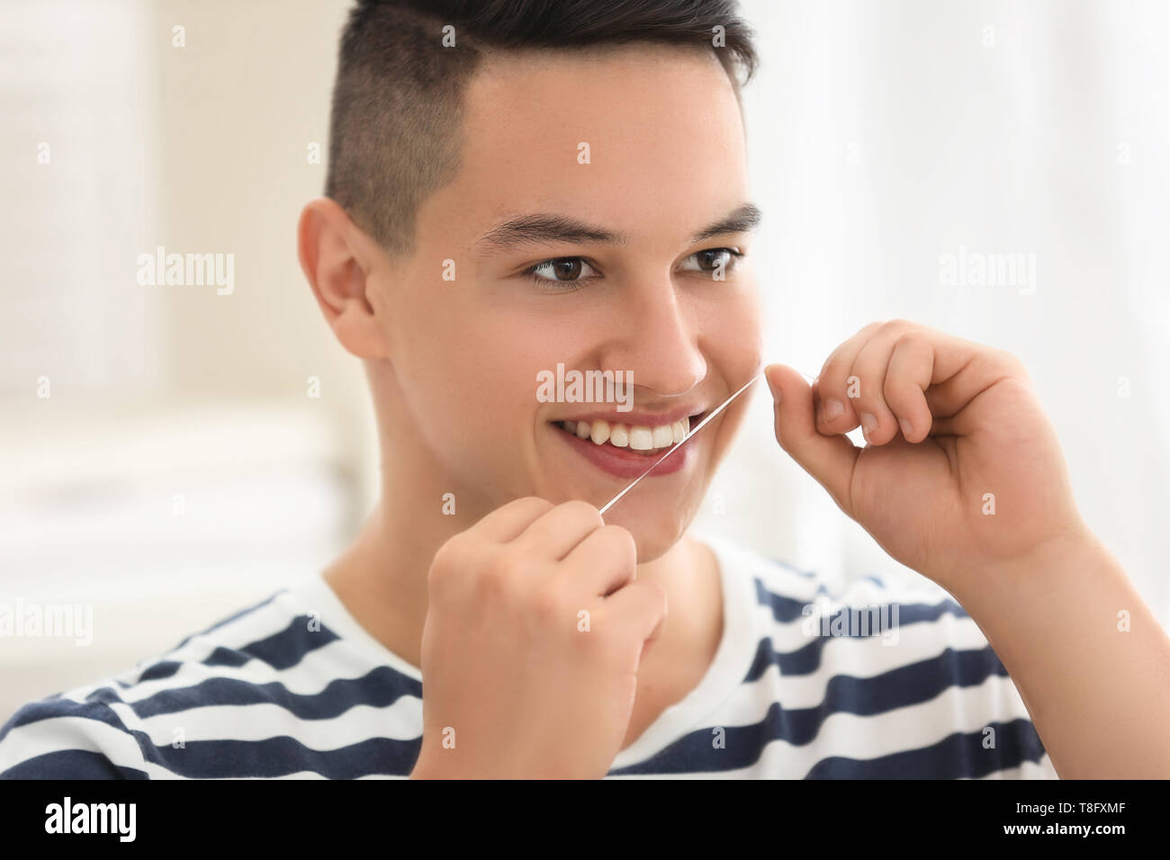Young man flossing teeth at home Stock Photo - Alamy