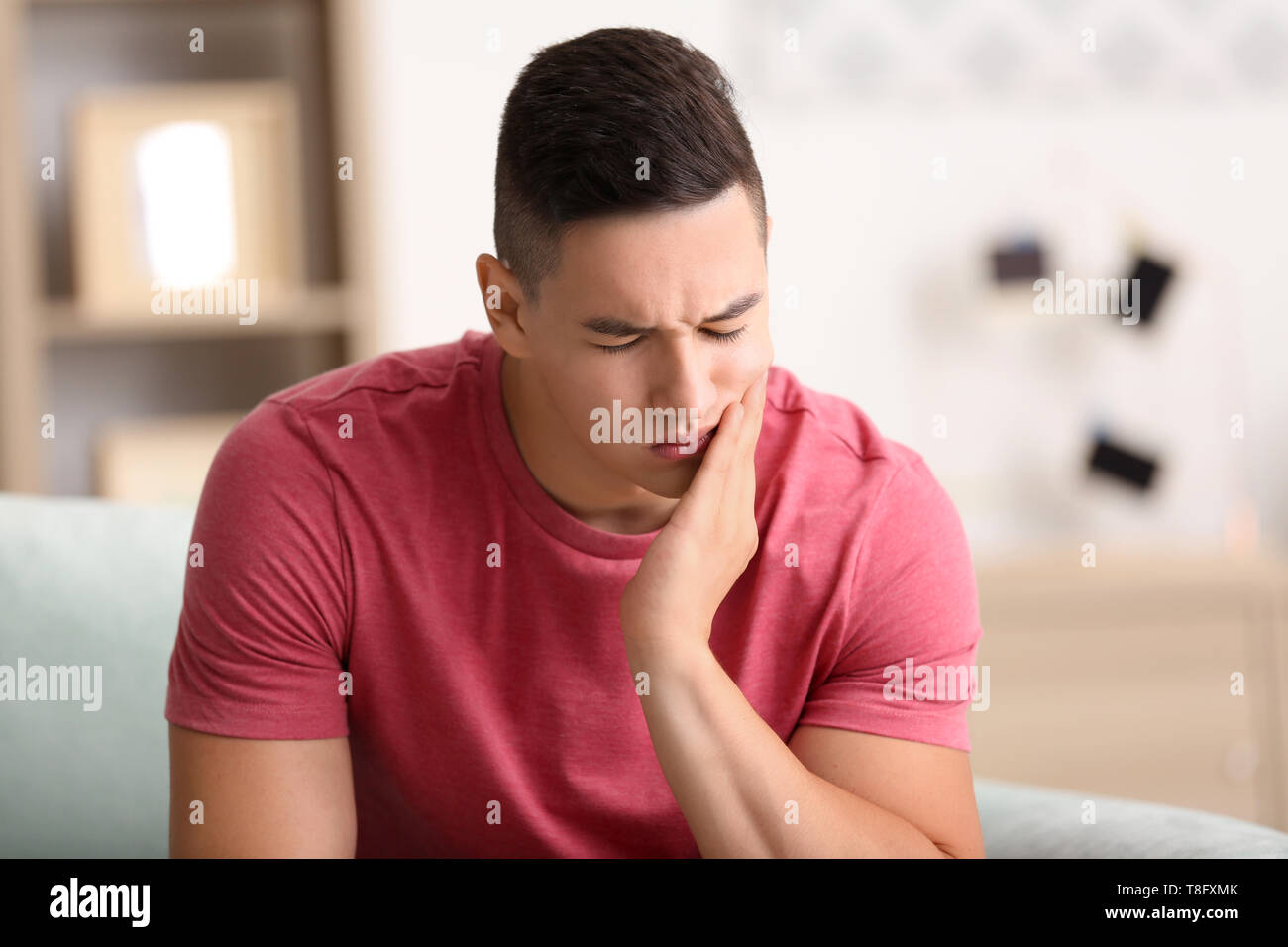 Young man suffering from tooth ache at home Stock Photo - Alamy