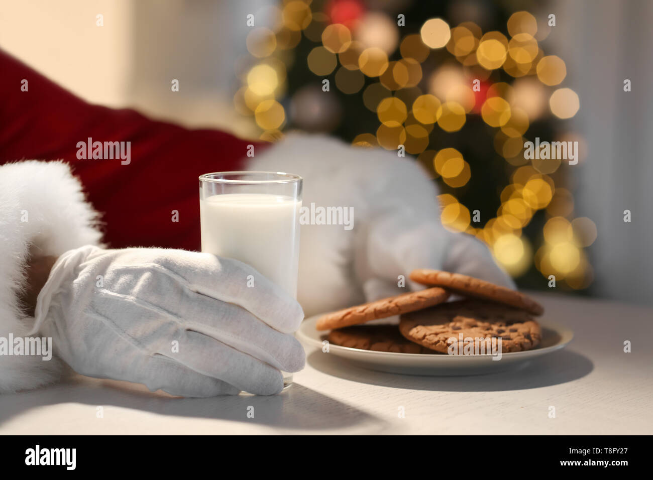 Santa Claus eating cookies and drinking milk at table, closeup Stock ...