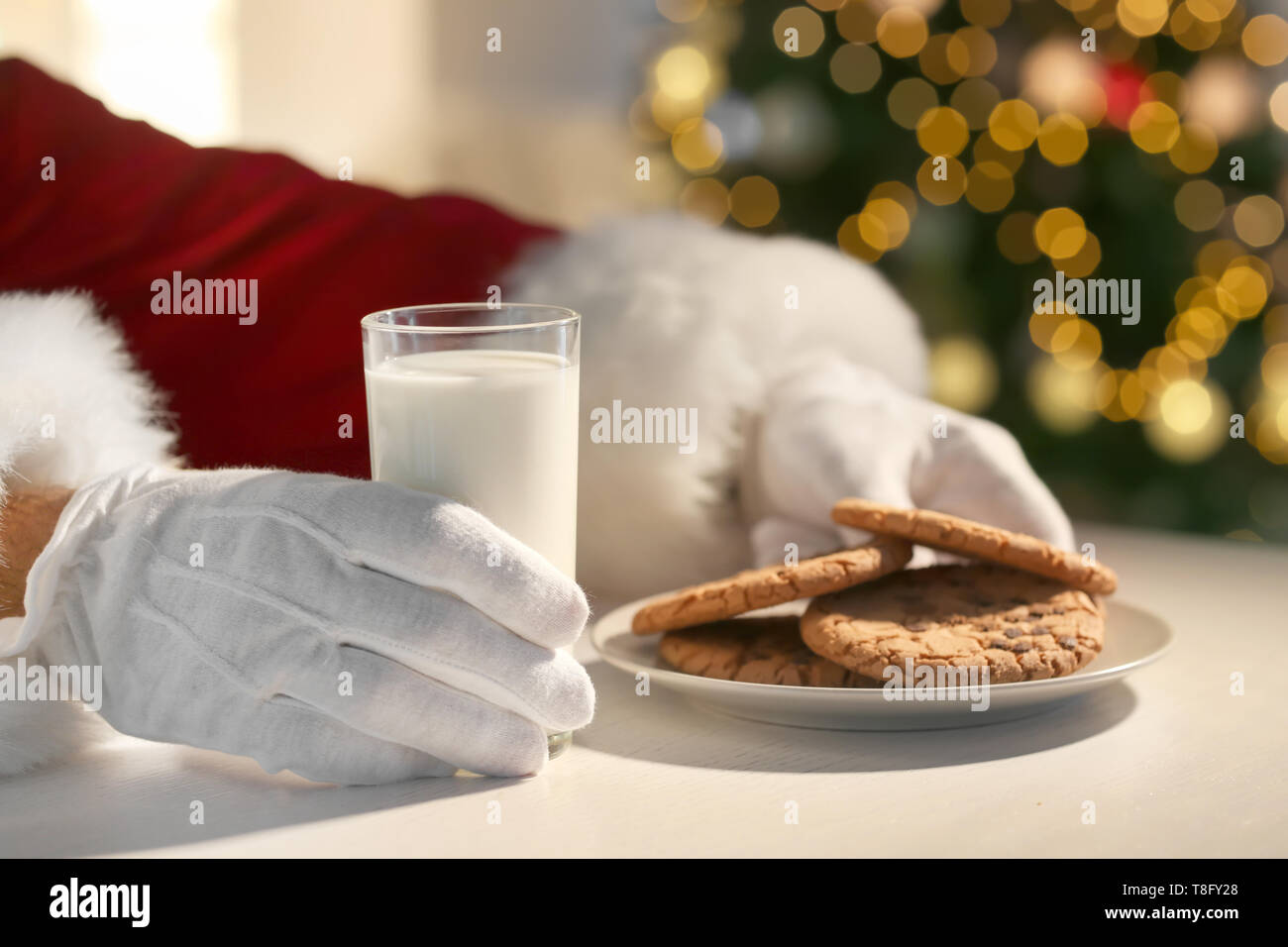 Santa Claus eating cookies and drinking milk at table, closeup Stock ...