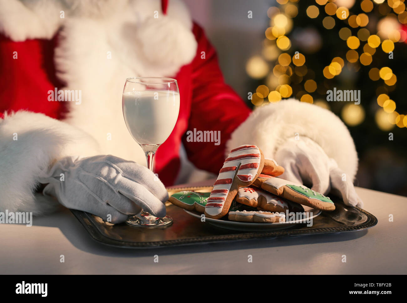Santa Claus eating cookies and drinking milk at table, closeup Stock ...