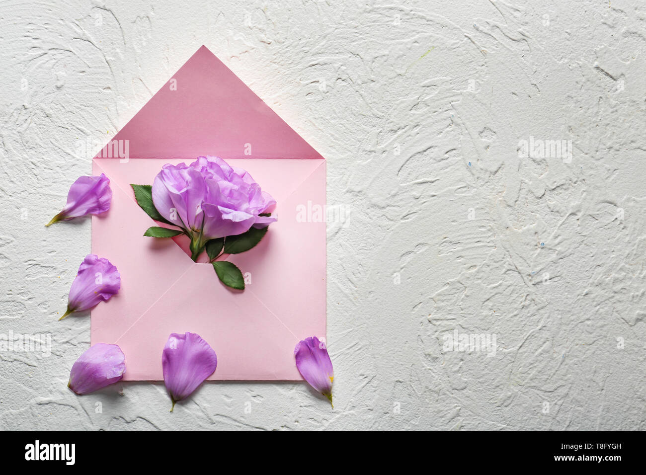 Open mail envelope with flower on light background Stock Photo - Alamy