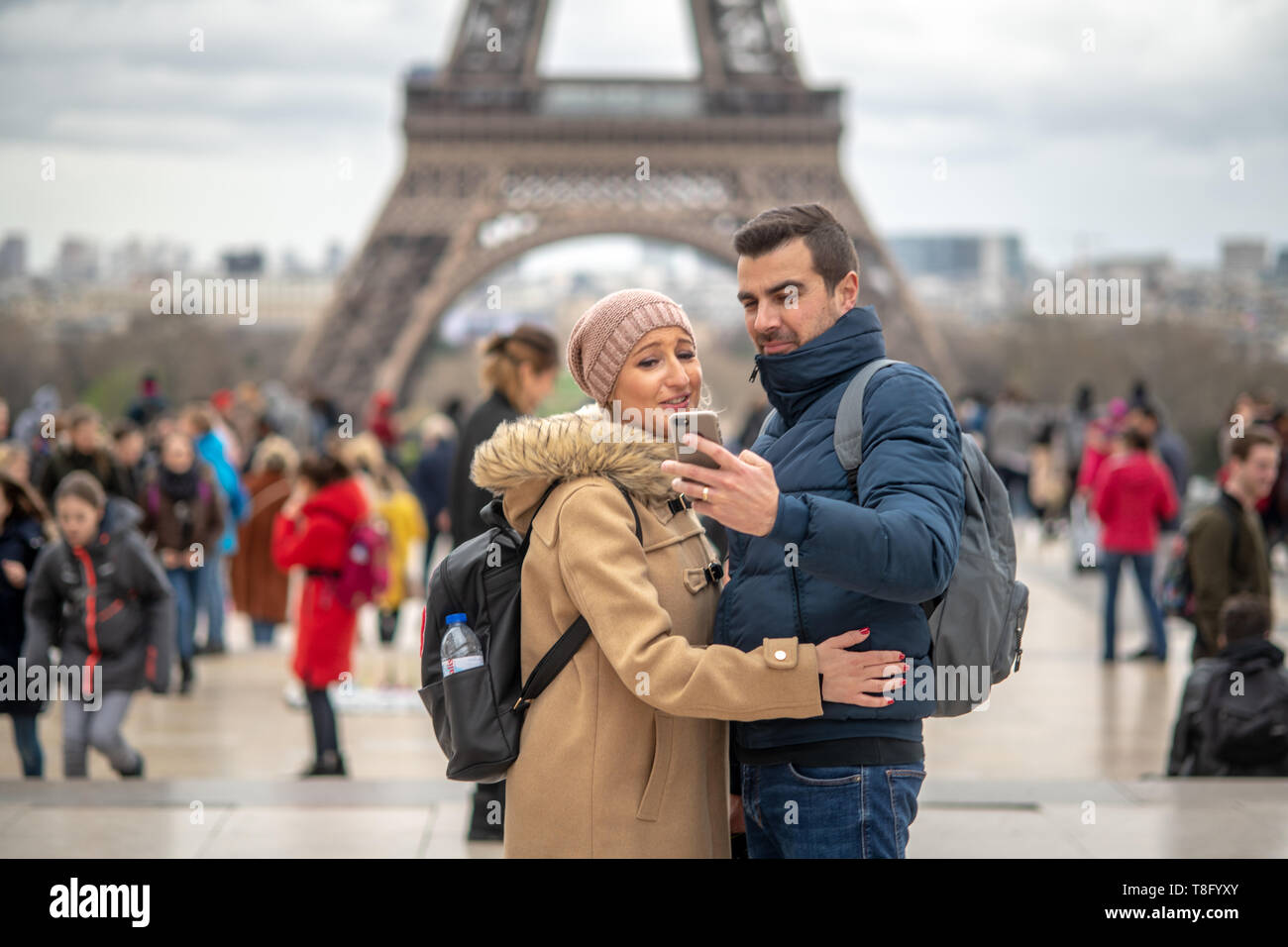 People posing out front of the Eiffel Tower, Paris, France. Eiffel ...