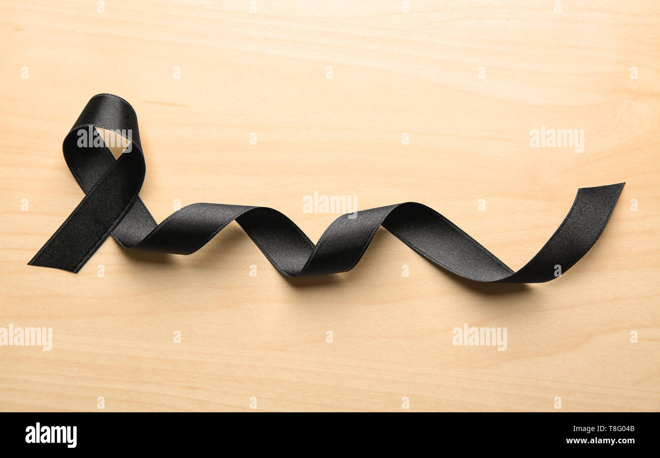 Black ribbon on wooden background. Melanoma concept Stock Photo - Alamy