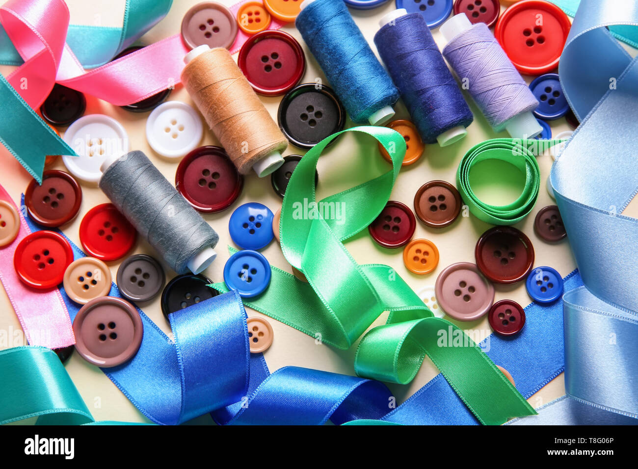 Different ribbons with threads and buttons on light background Stock ...