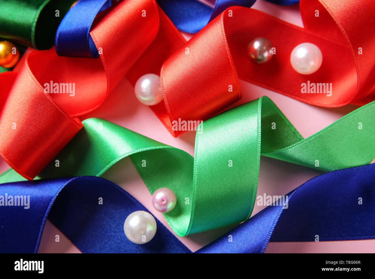 Different ribbons with beads on color background Stock Photo - Alamy