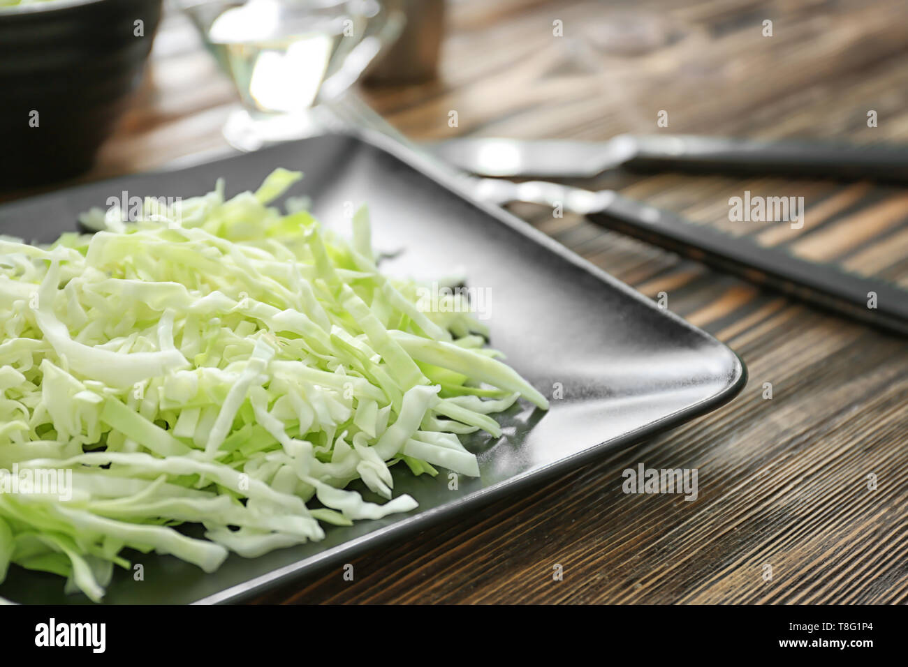 Plate with cut cabbage on wooden table, closeup Stock Photo - Alamy